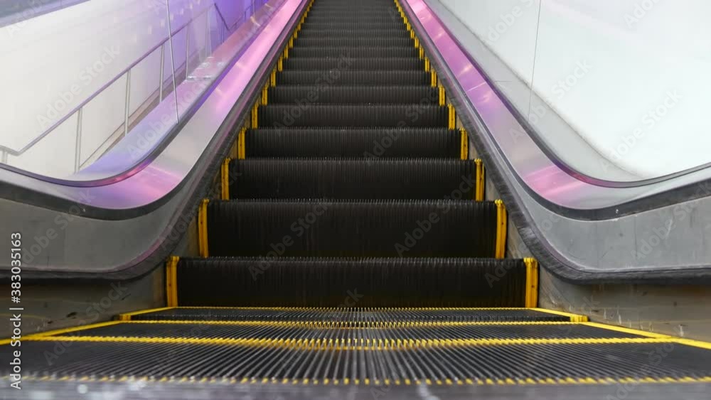 Low angle looped perspective view of modern escalator stairs. Automated ...
