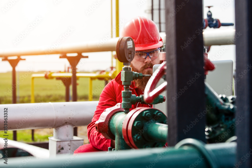 Oil worker turning valve on oil rig Stock Photo | Adobe Stock