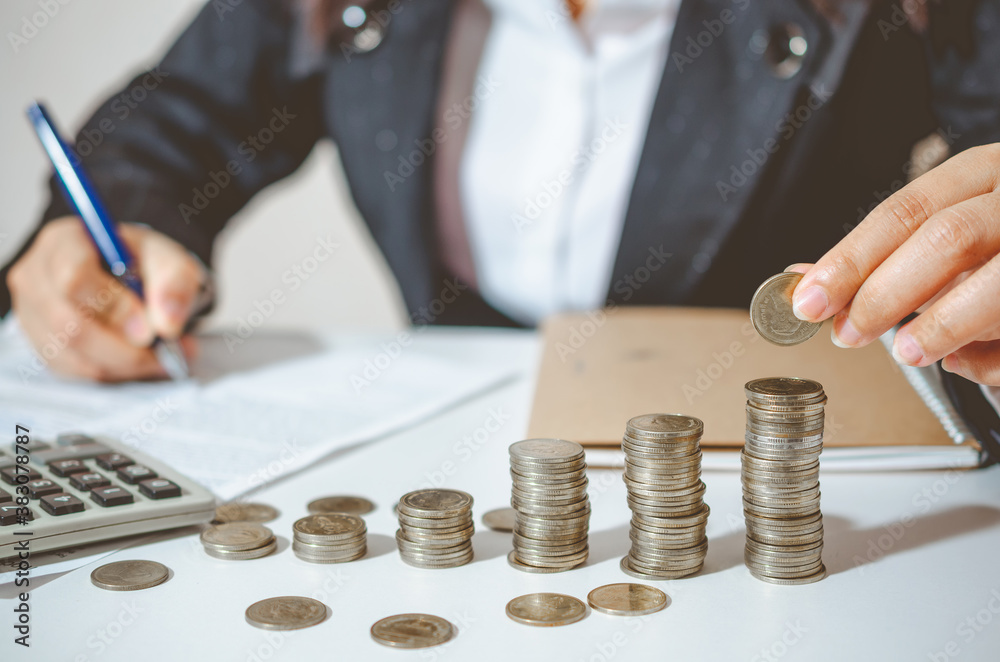 Closeup image businesswoman holding coins putting to stacking coins ...