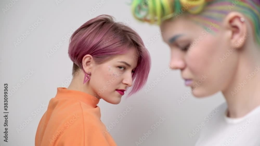 Two young girls with bright colored dyed hair and short haircuts ...
