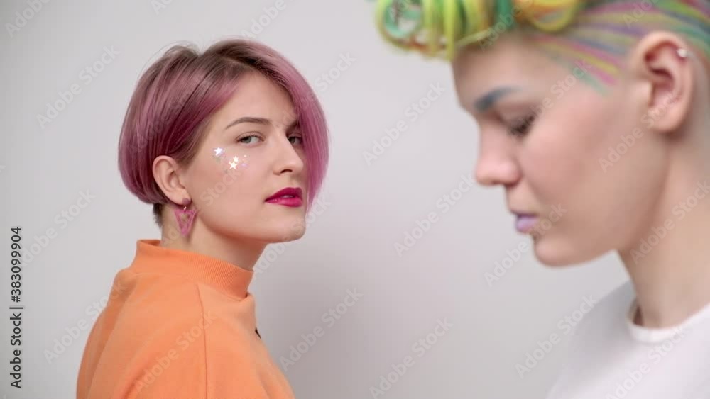 Two young girls with bright colored dyed hair and short haircuts ...
