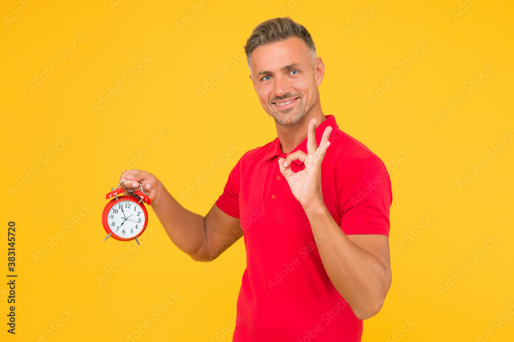 All right. Happy man hold alarm clock showing OK sign. Punctuality and ...