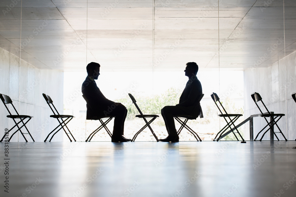 Silhouette businessmen sitting face to face Stock Photo | Adobe Stock