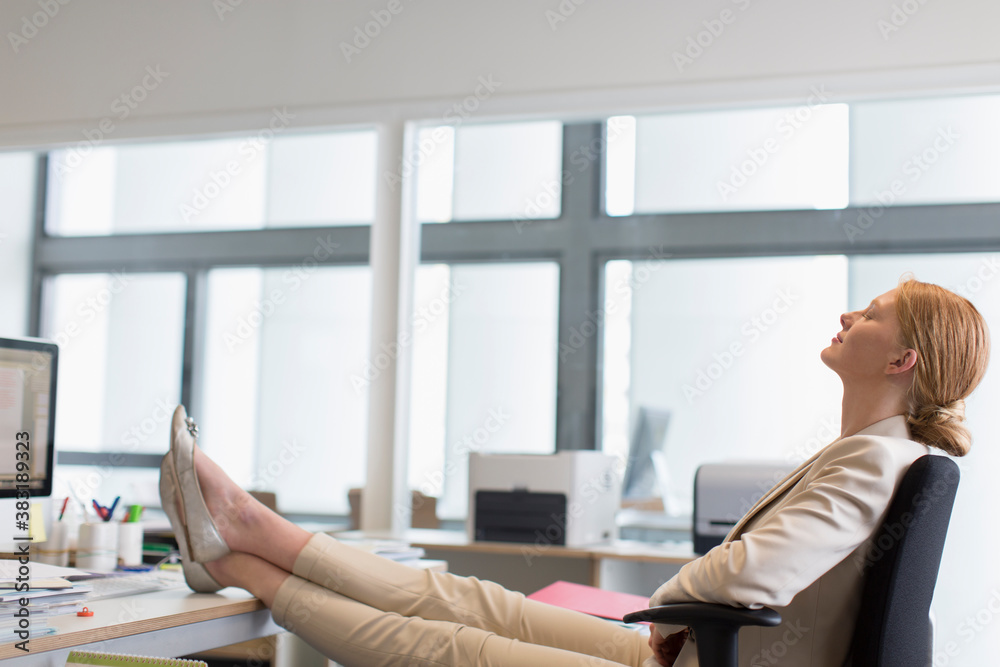 Businesswoman relaxing with feet up on desk in office Stock Photo ...