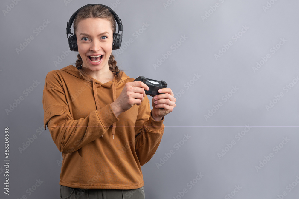 Beautiful smiling gamer girl with pigtails playing video game using ...