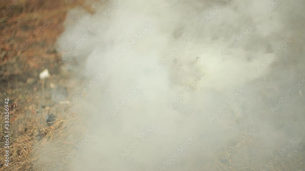 Video, thick smoke from a flaring fire, orange flames in white smoke ...