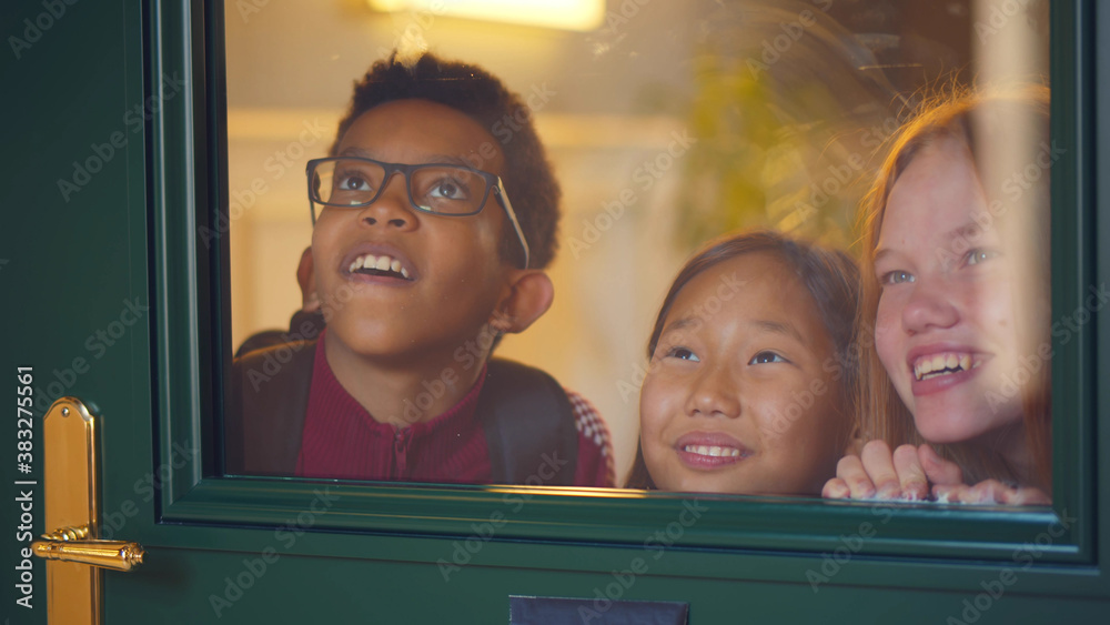 Happy diverse classmates peeking through glass door waiting for end of ...