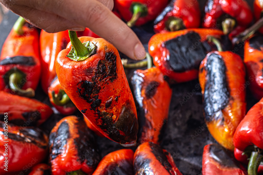 Red peppers roasting on a wood-fired stove Stock Photo | Adobe Stock