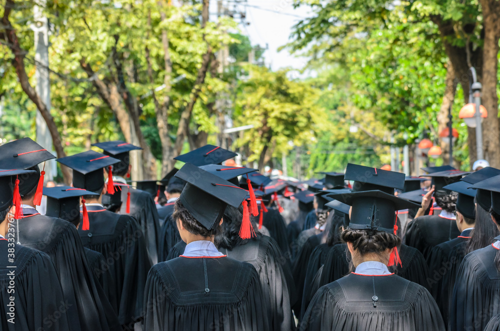 The shot of graduation hats and the back of graduates during ...