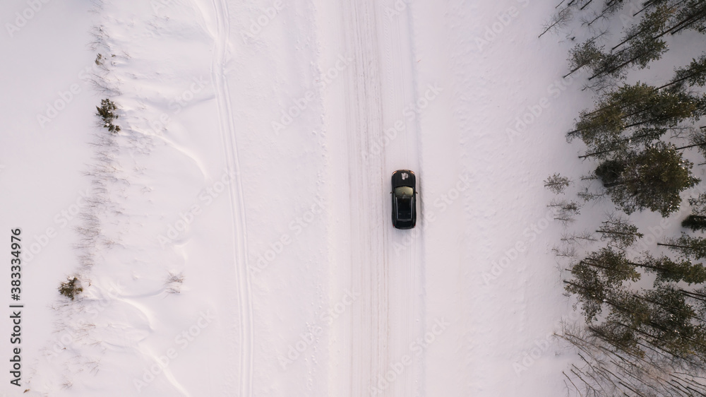Aerial top view from drone of suv vehicle driving on snowy ice road ...