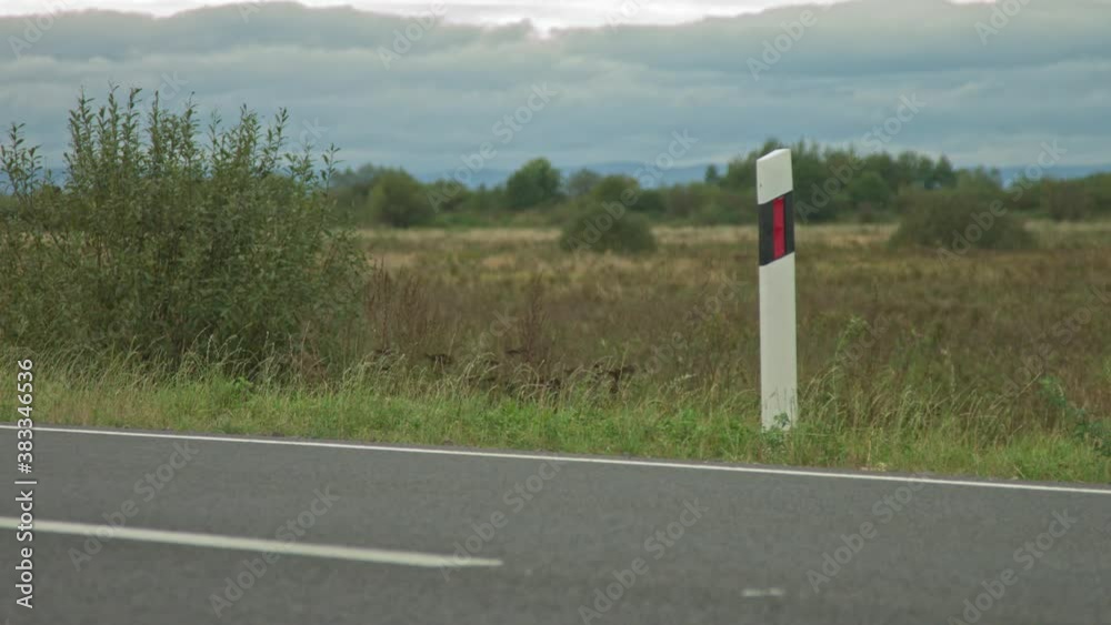 Curvy road with traffic signs in mountains. Red diagonal keep left ...