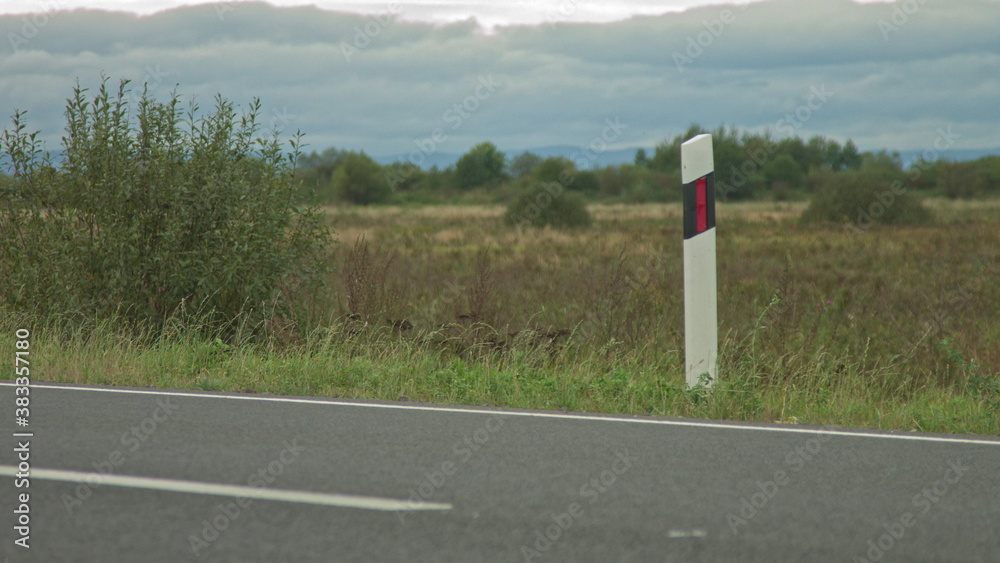 Curvy road with traffic signs in mountains. Red diagonal keep left ...