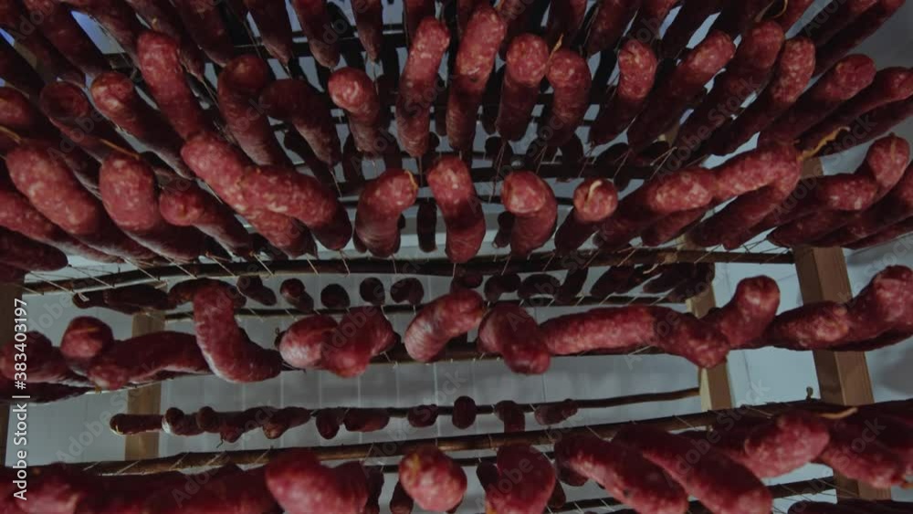 Inside large smokehouse are stored various types of salami and sausages ...