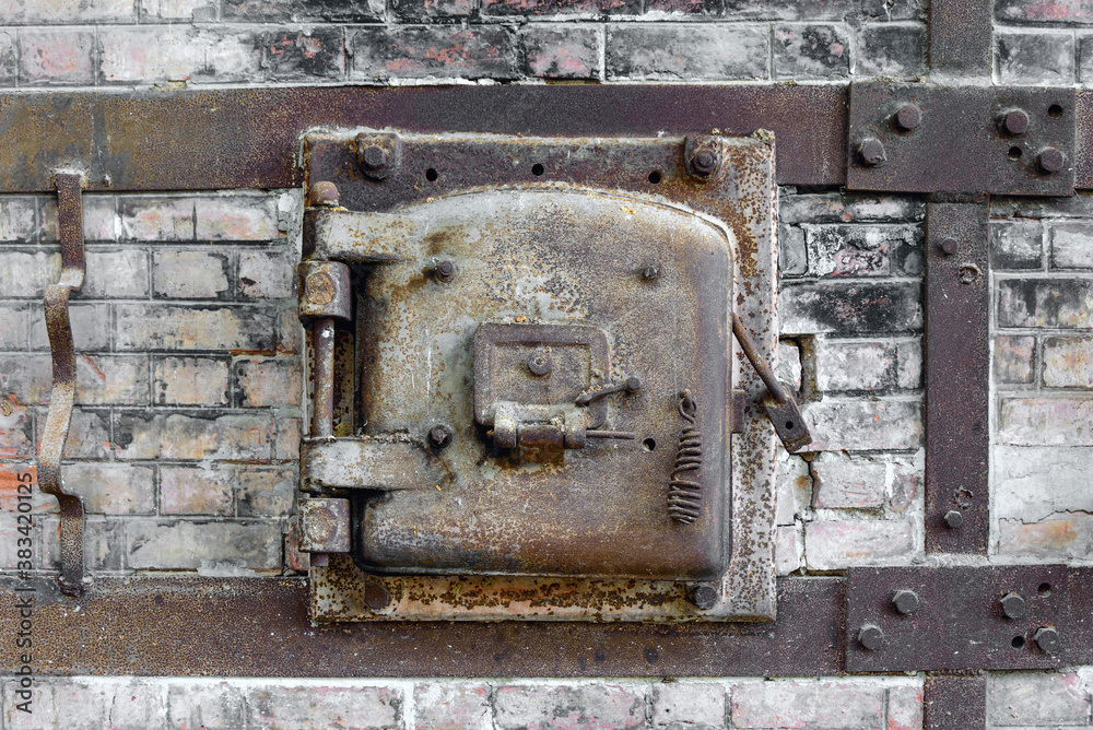 Rusty old metal hatch door of a red brick kiln in an abandoned factory ...