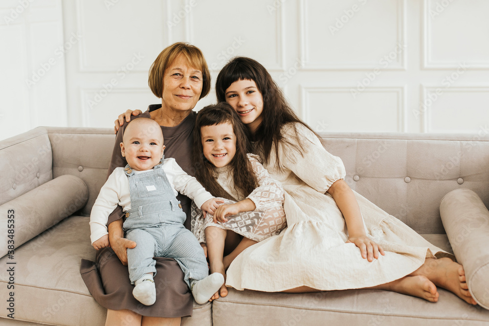 Portrait of a beautiful grandmother and her three grandchildren. Woman ...