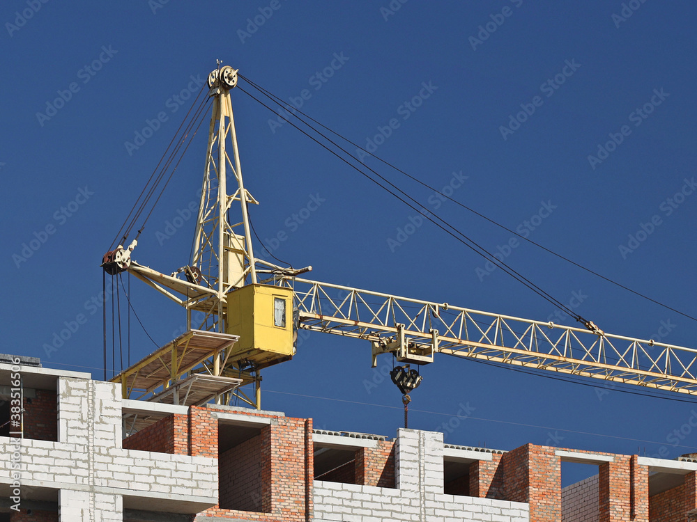 Two crane operators in overalls repair a high-rise tower crane working ...