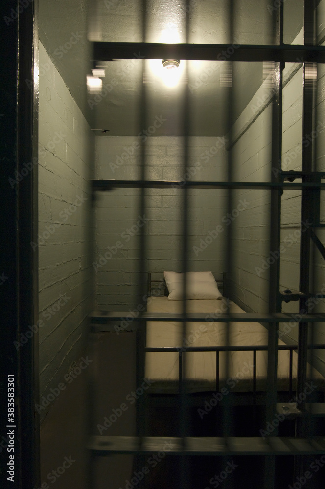 Interior of empty prison cell with bed in it Stock Photo | Adobe Stock