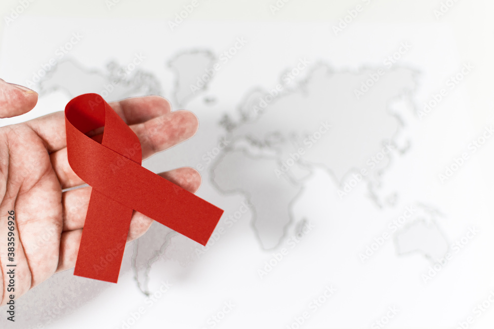 World Aids Day, hand with red ribbon symbol on world map background ...