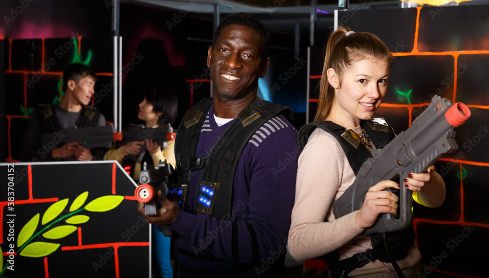 Two laser tag players of different nationalities standing back to back ...