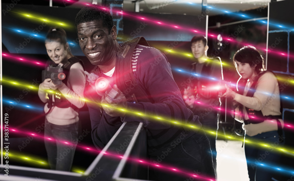 Emotional African man with a laser pistol playing laser tag with ...