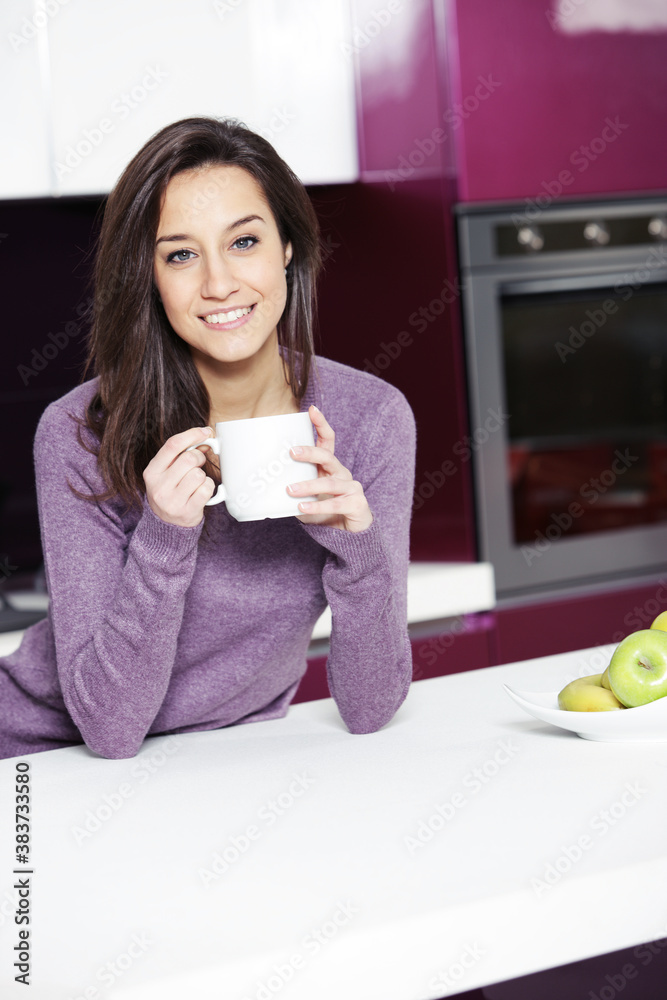 Beautiful young woman having coffee while at the kitchen Stock Photo ...