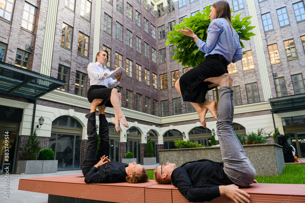 Foto de Acroyoga concept with four people, two base men lay on bench at ...