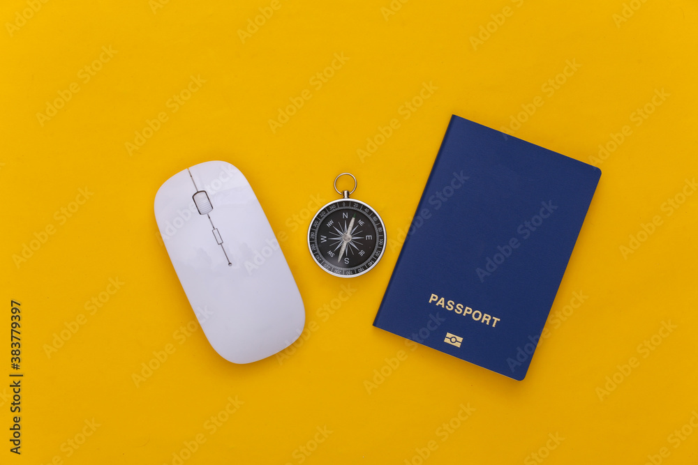 Compass, pc mouse and passport on a yellow background. Top view ...