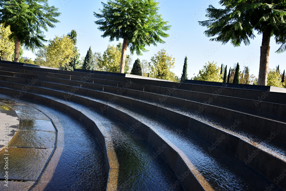 The water cascades down the concrete steps, and a beautiful tree grows ...