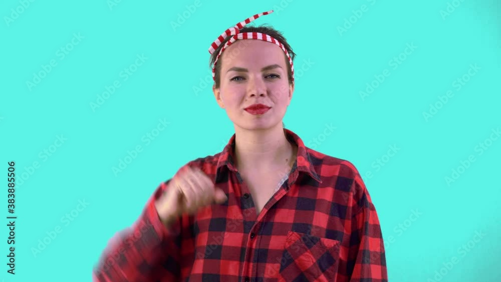 Stylish and beautiful housewife in pin-up style gives an iron for a ...