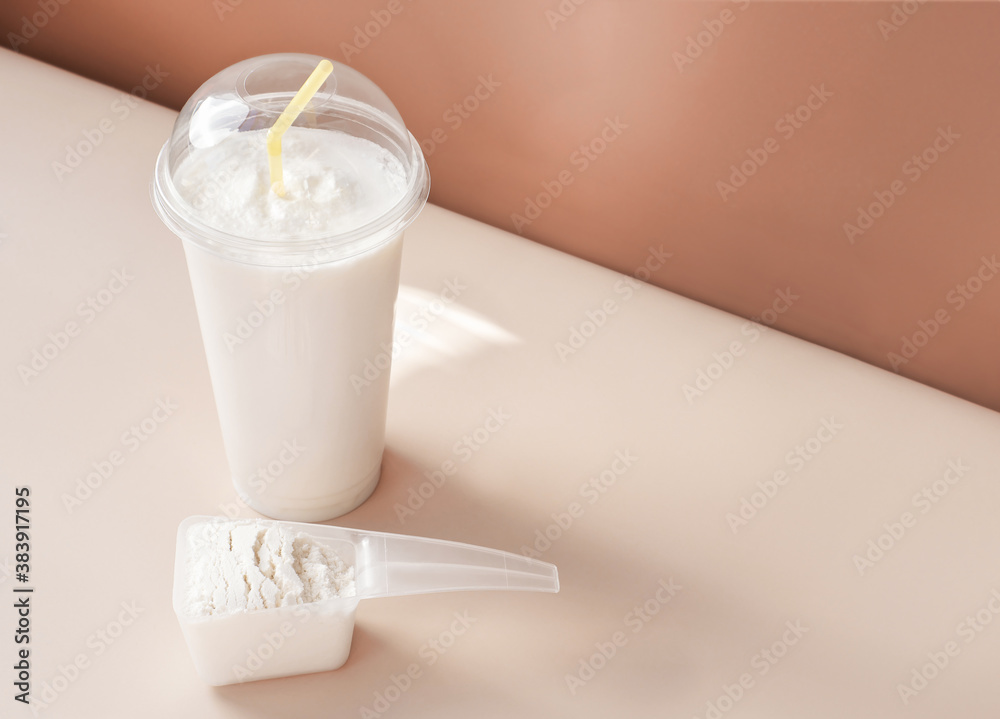 whey protein cocktail in a disposable cup and scoop of collagen powder ...
