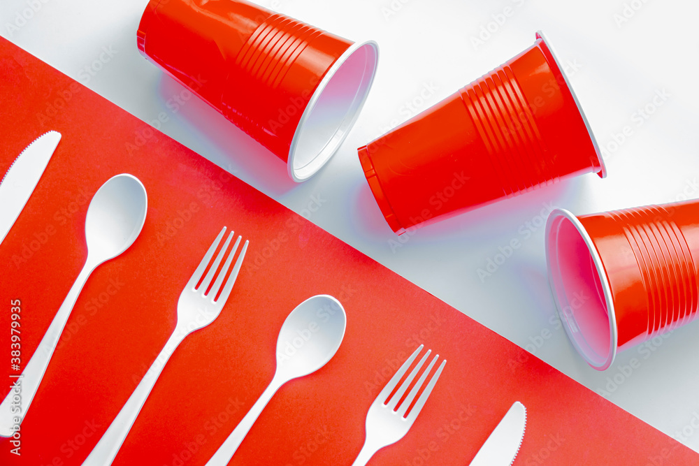 Horizontal view of single use white plastic cutlery and red plastic ...