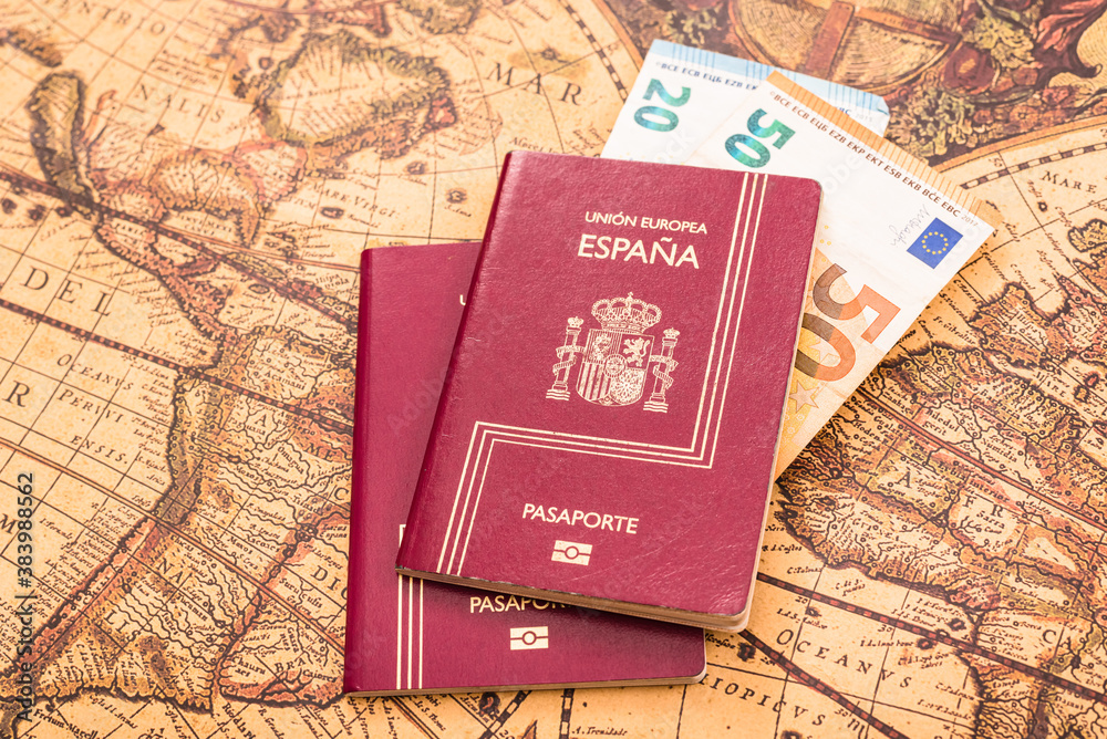 Spanish passport with euro bills inside, on a world map for travelers ...