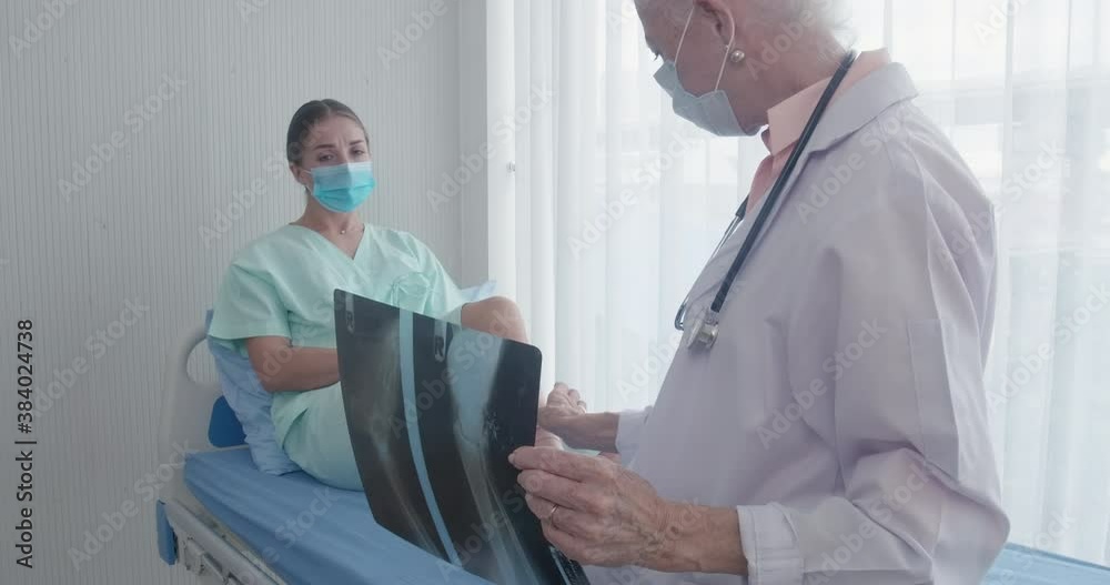 Doctor explain bone of patient about injury symptom on bed with X-ray ...