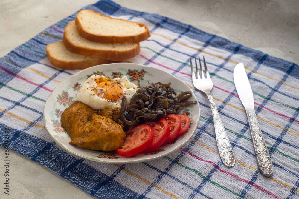 Healthy simple breakfast with poached egg, chicken steak, seaweed salad ...