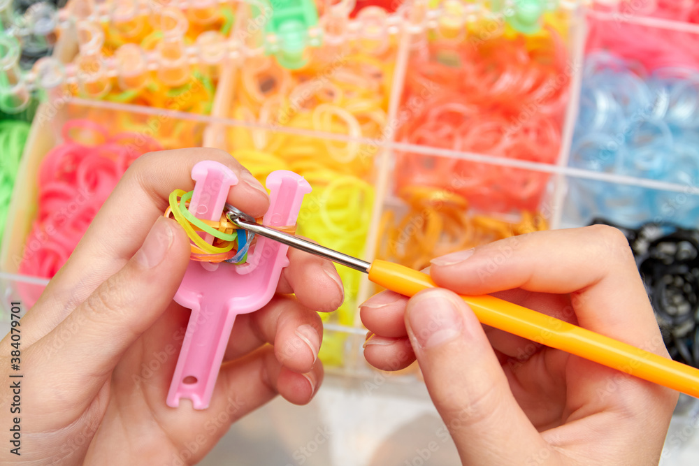 Rubber Band Weaving. Knitting rubber bands with loom knit. Hands of ...