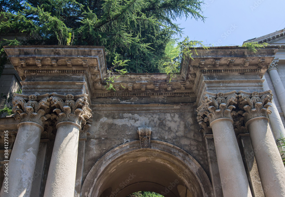 The upper part of the old building with stucco, arches and columns ...