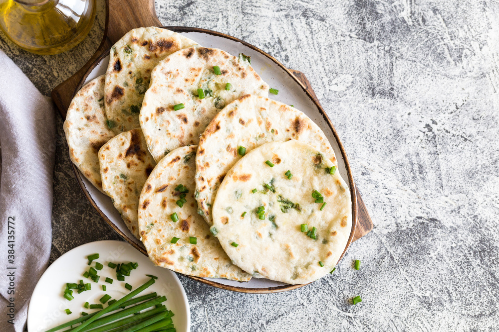 Onion naan - traditional indian bread. pita bread or scones with green ...