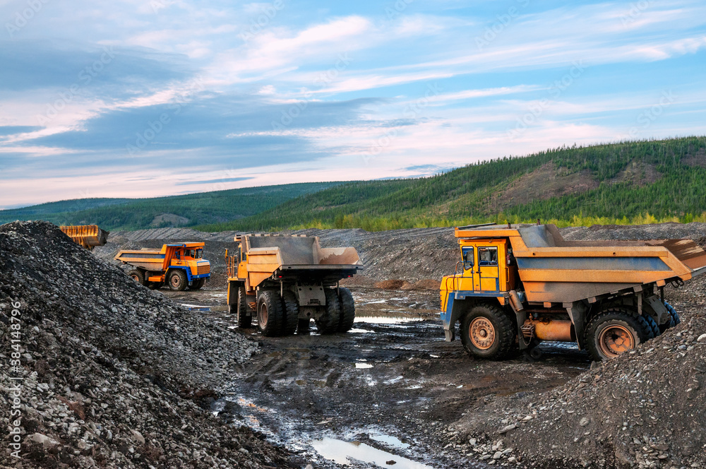 Loading of mountain soil into the body of a mining dump truck using a ...