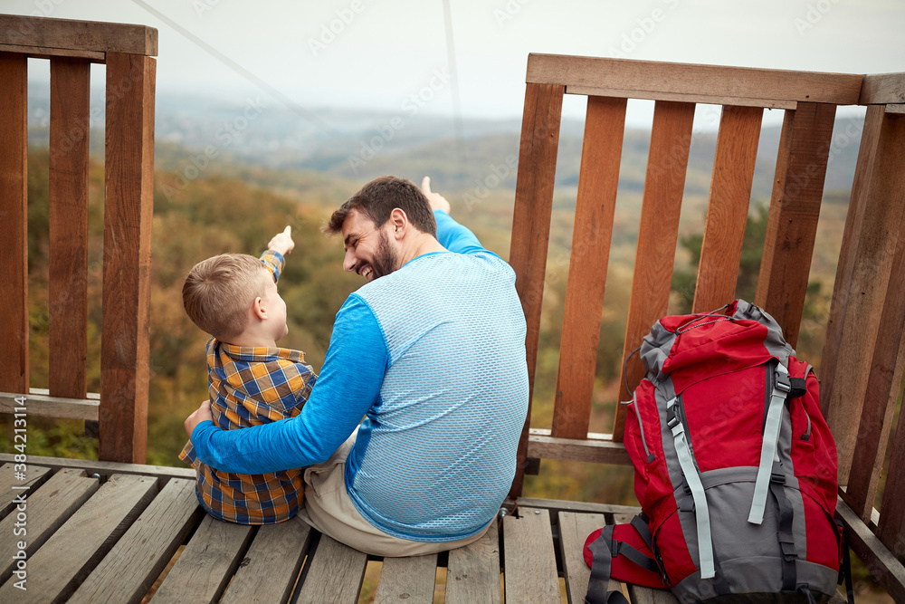 Father and son enjoying an awesome view of the forest from the top of a ...