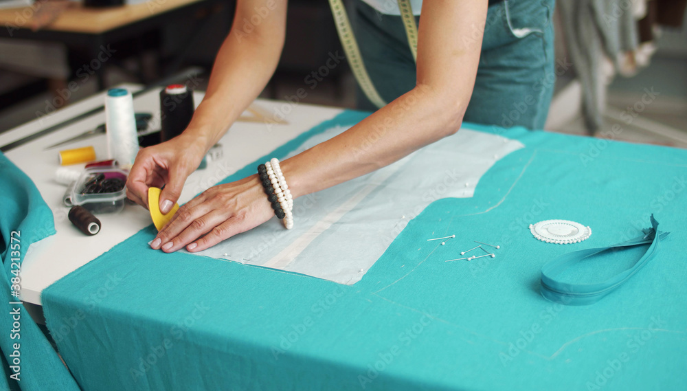 Woman hands tracing lines on blue fabric with tailors chalk ...