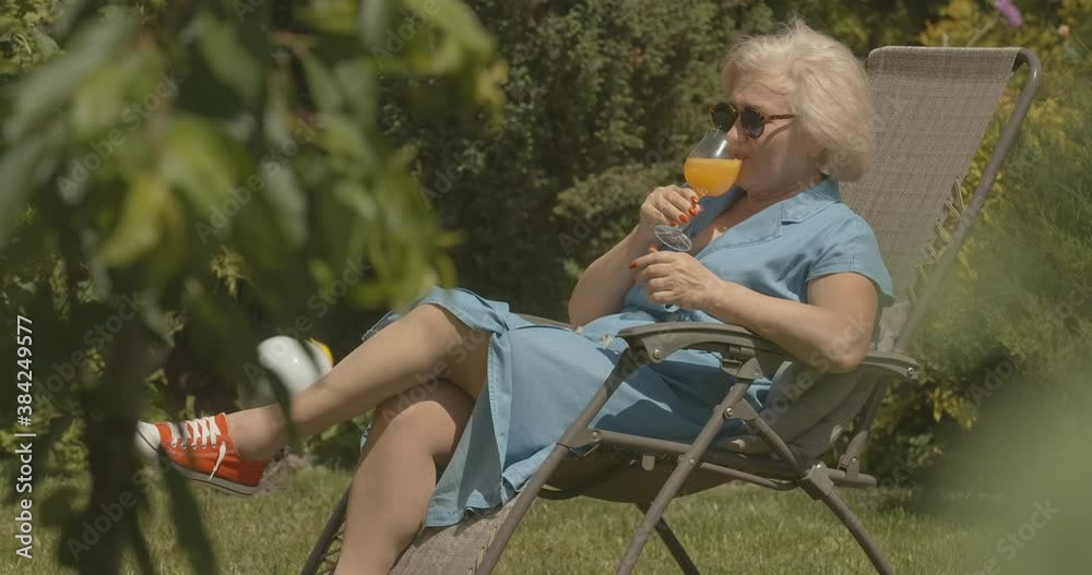 Wide shot side view of positive senior woman in sunglasses laughing and ...