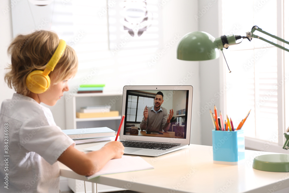 Little boy studying with teacher via video conference at home. Distance ...