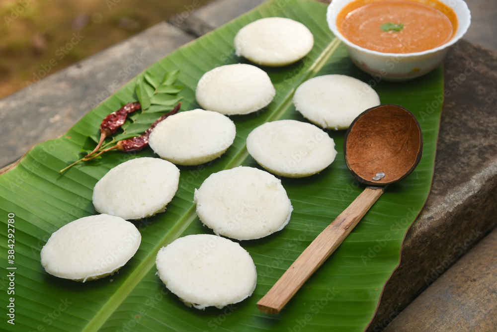 Indian idly served on traditional banana leaf vegetarian food. Lots of ...