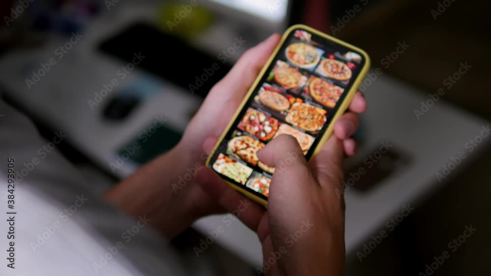 Ordering pizza using online delivery. A man orders food at home in an ...