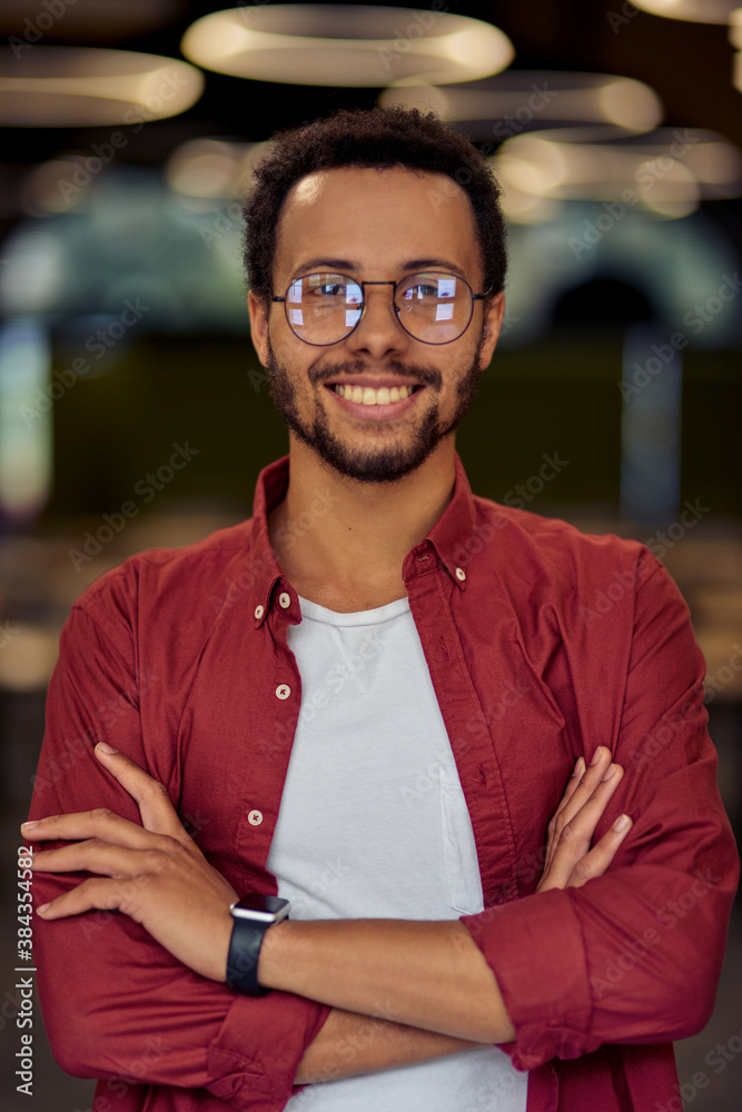 Foto de Vertical shot of a young happy mixed race businessman or office ...