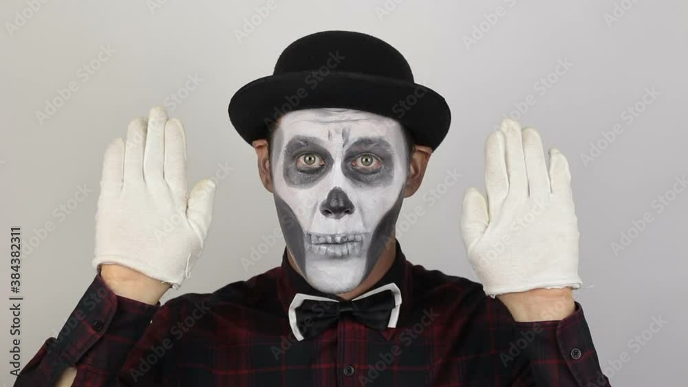 A terrible man in clown makeup waves his hand to say goodbye to his ...