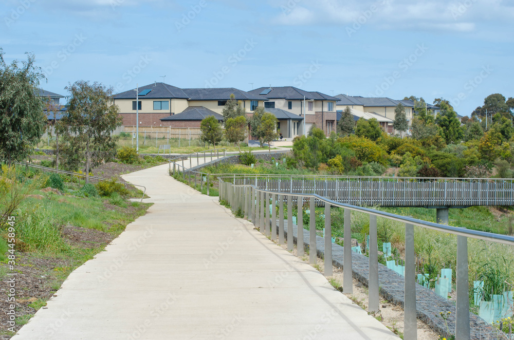 Concrete pedestrian footpath/cyclist path leads to some modern two ...