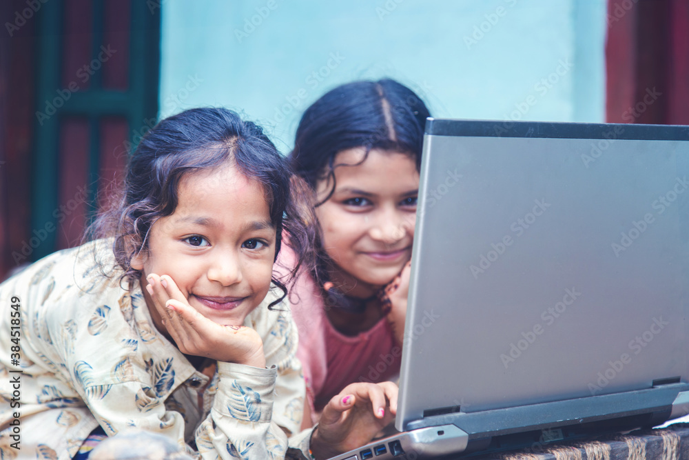 Indian village girls operating laptop computer system seating at home ...