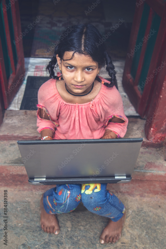 Indian village girl operating laptop computer system seating at home ...