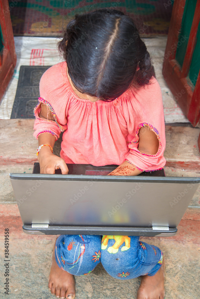 Indian village girl operating laptop computer system seating at home ...